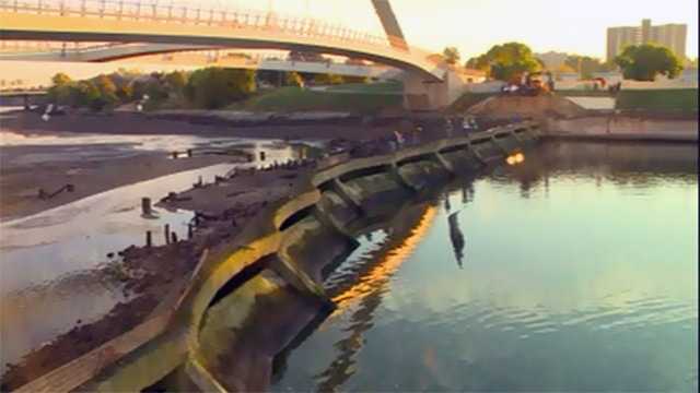 Workers installing new flashboards on downtown dam