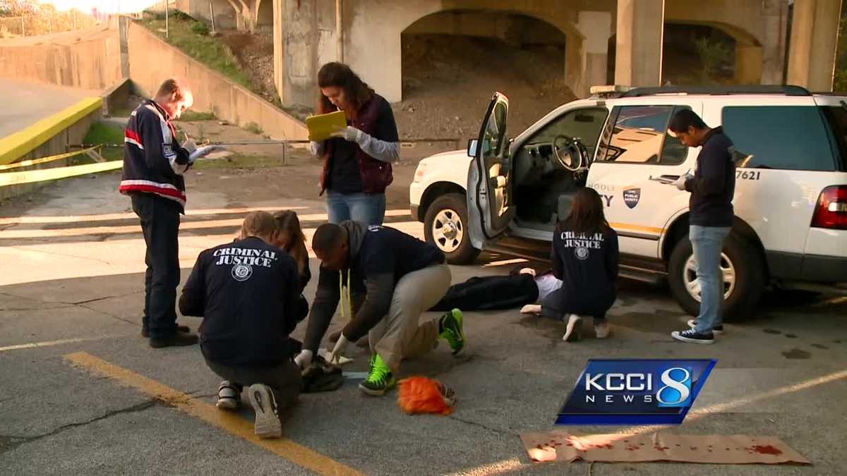 High school students study mock crime scene in forensic class