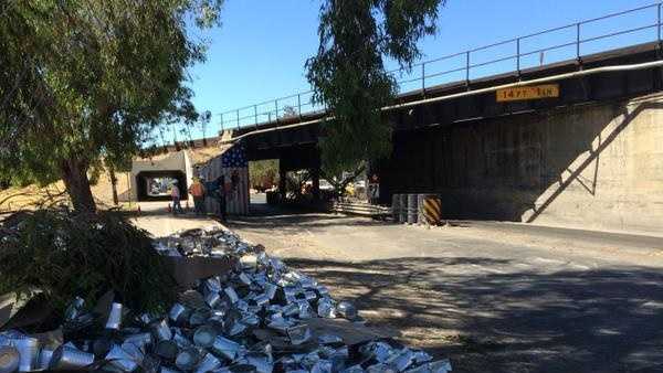 Big rig hits train trestle on Hwy. 70, spills cans