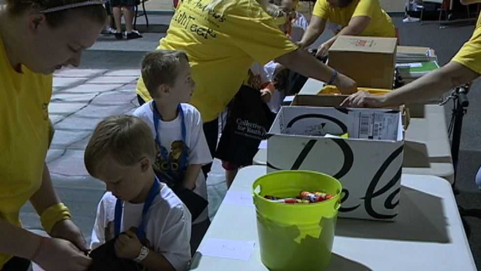 Students fill backpacks for kids