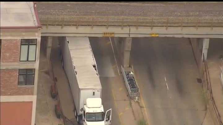 Semi-truck stuck under downtown bridge