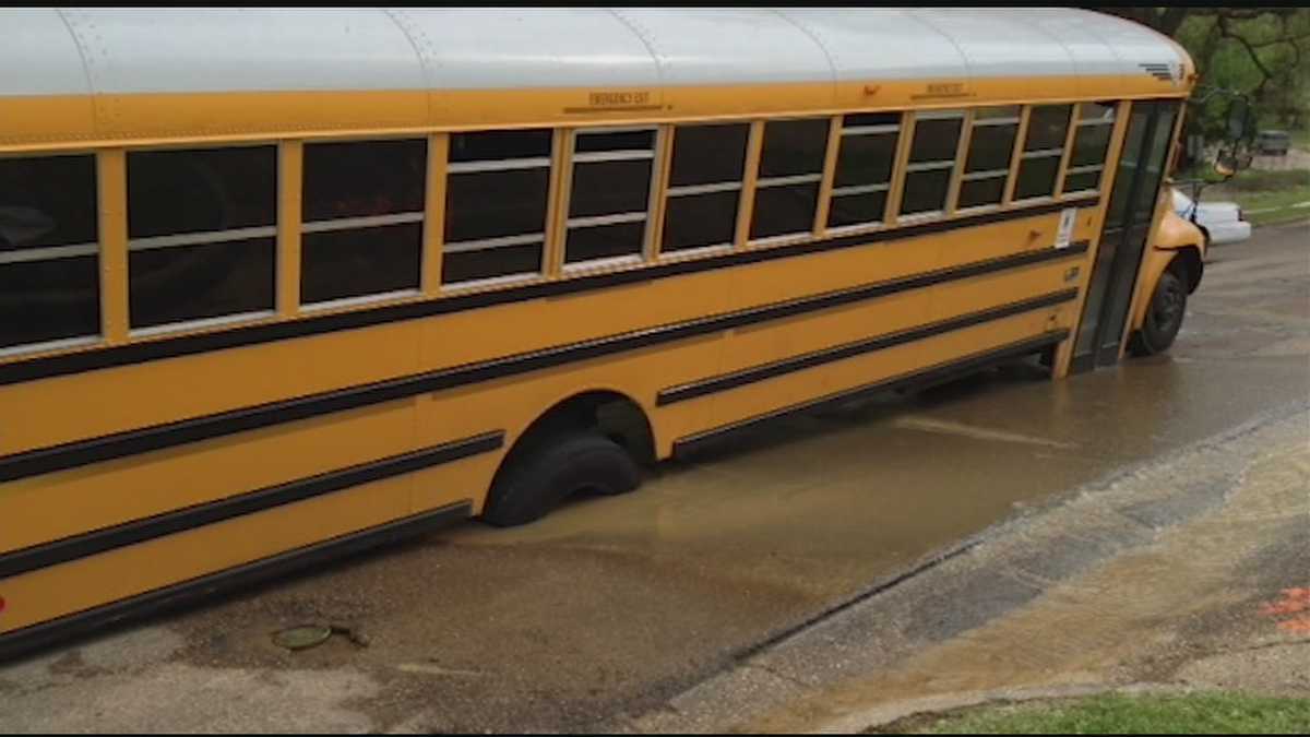 School bus with kids gets stuck in a hole
