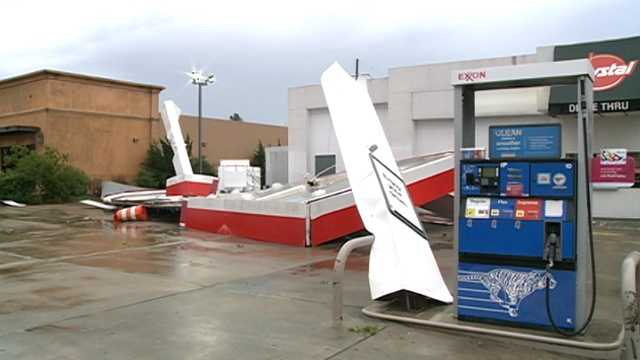 Storm damages gas station, trapping man inside car