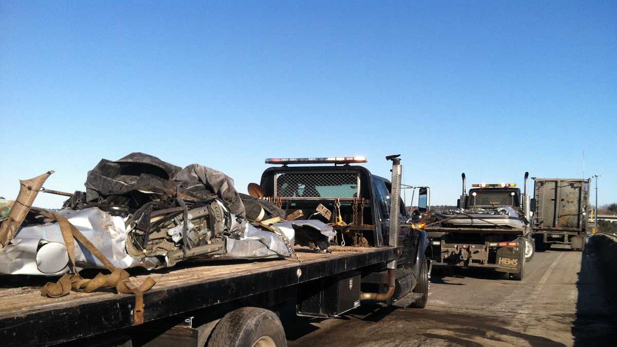 Crushed cars fall off truck on highway