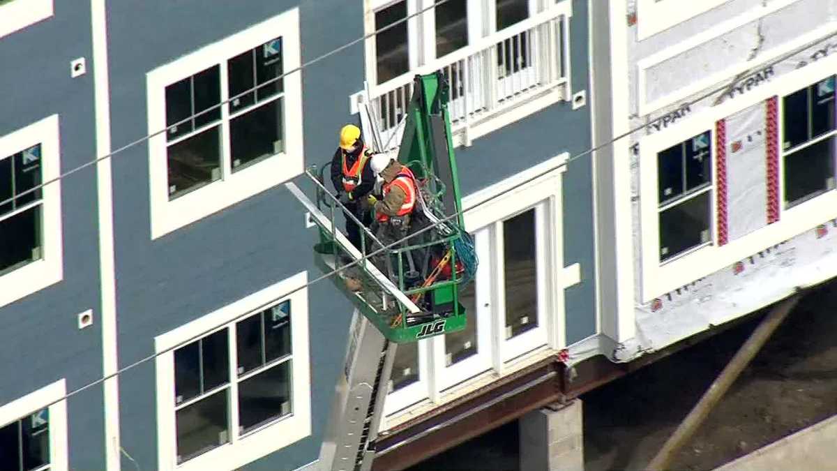 Workers back on solid ground after getting stuck in cherry picker