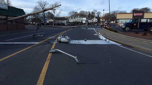 Four utility poles snap, fall onto road