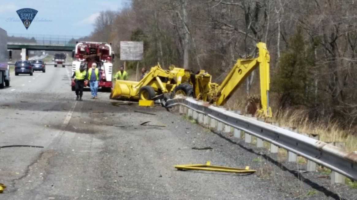 Backhoe hits overpass, falls off trailer
