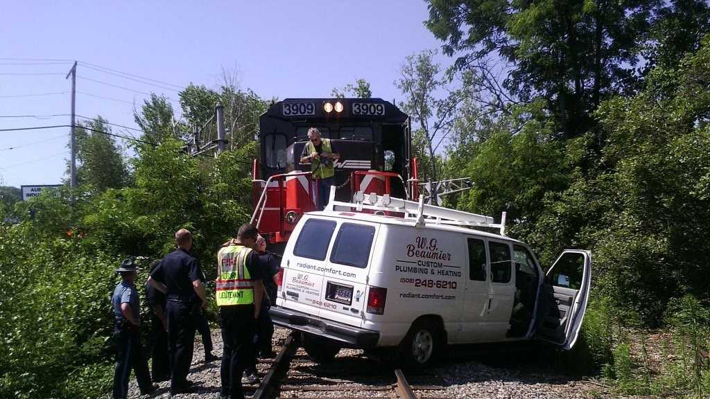 Train collides with van, pushes it down tracks