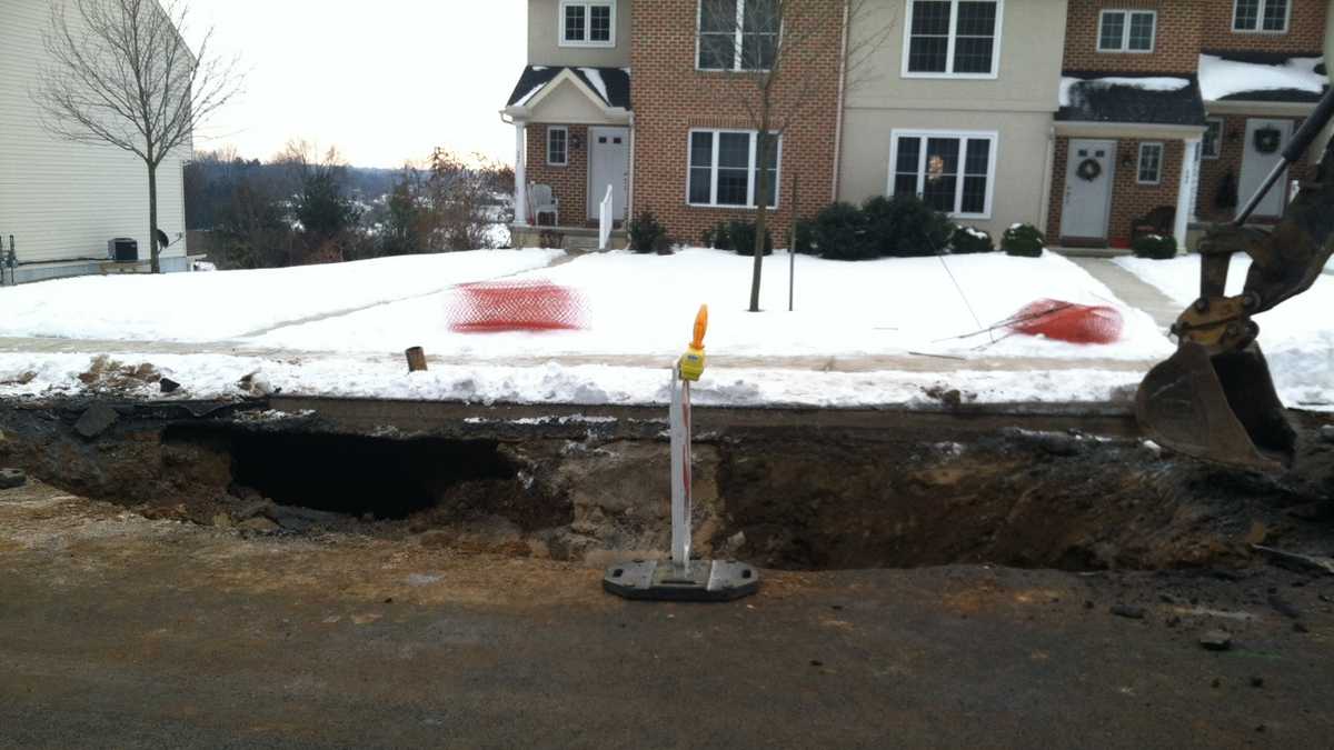 Sinkhole opens under neighborhood street
