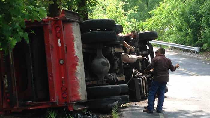 Dump truck tips over on curvy road