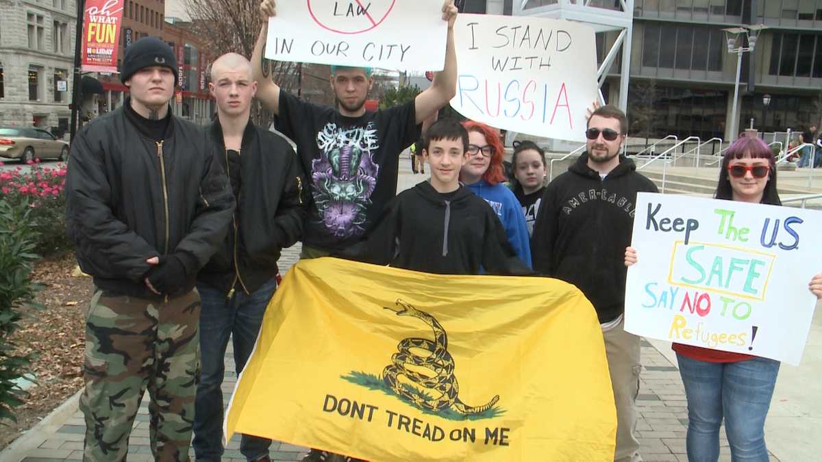 Anti-refugee protesters gather outside KFC Yum! Center before UofL game