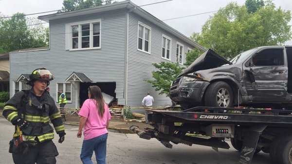 Woman taken to hospital after car crashes into living room