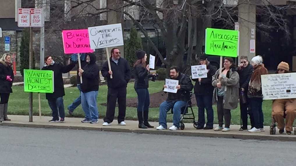 Fugitive doctor's patients protest outside hospital