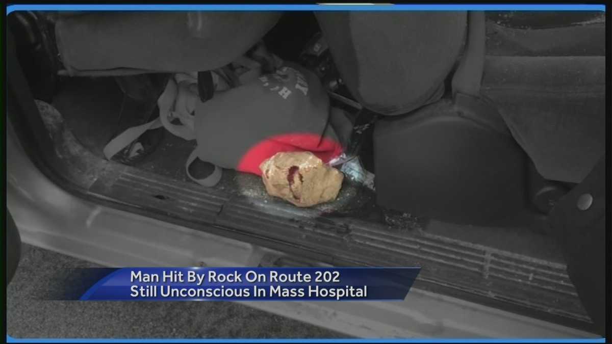 Man hit by rock in car remains unconscious at hospital