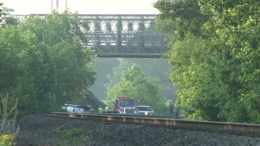 Truck crashes through bridge detour, flies over railroad tracks