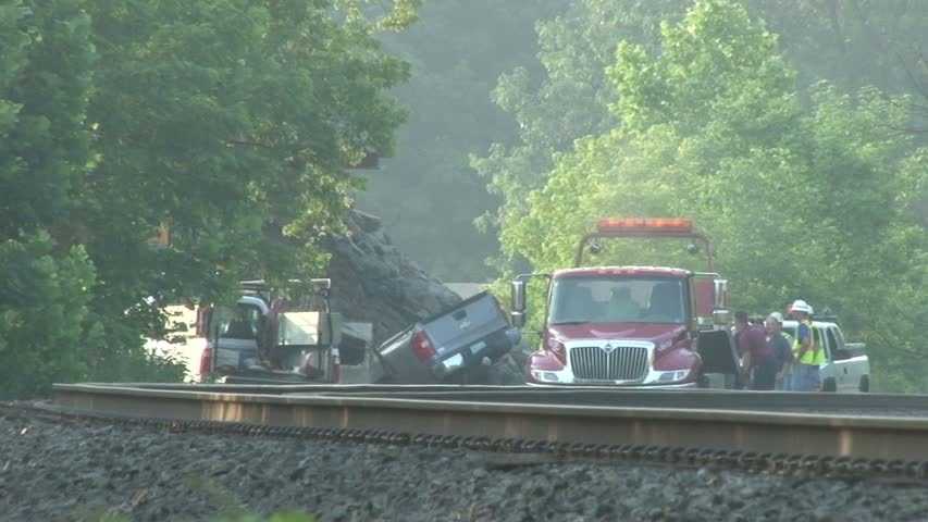 Truck crashes through bridge detour, flies over railroad tracks