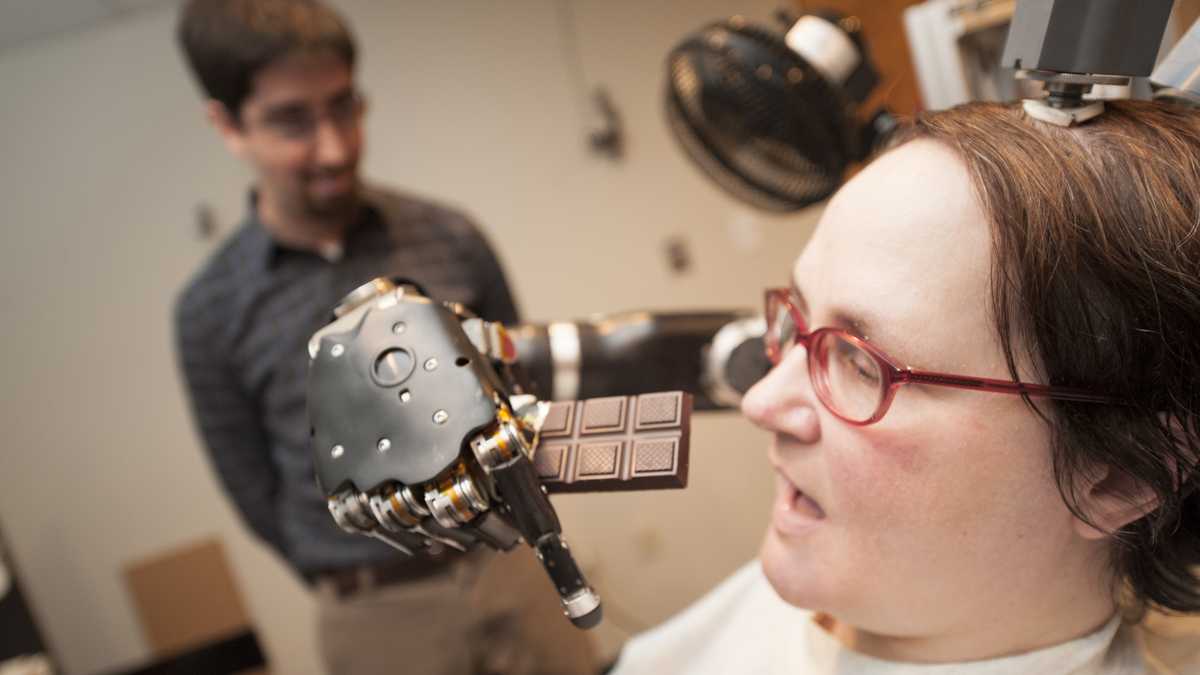 Quadriplegic feeds herself with mind-controlled robot arm
