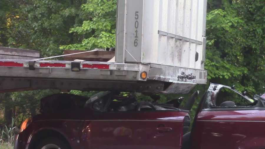 Photos: Car goes under truck's disengaged trailer