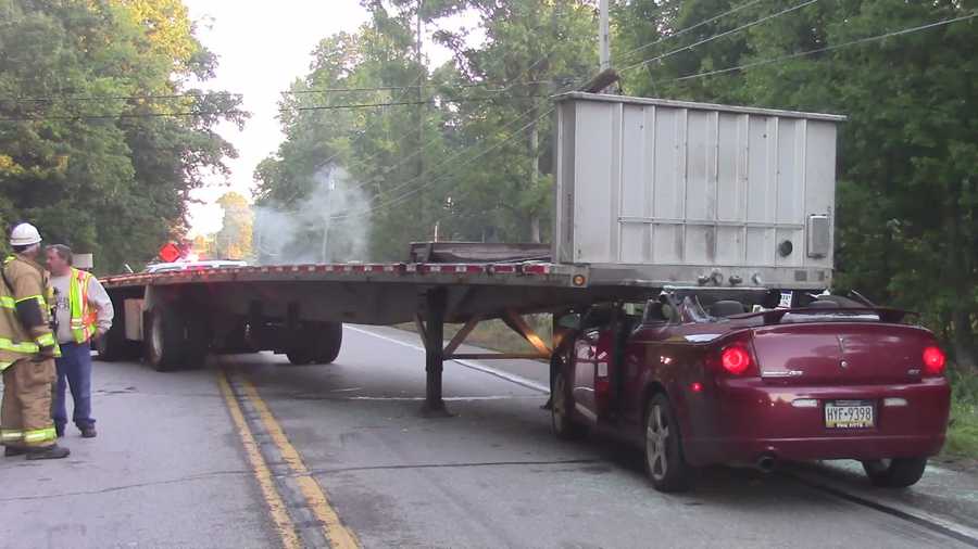 Photos: Car goes under truck's disengaged trailer