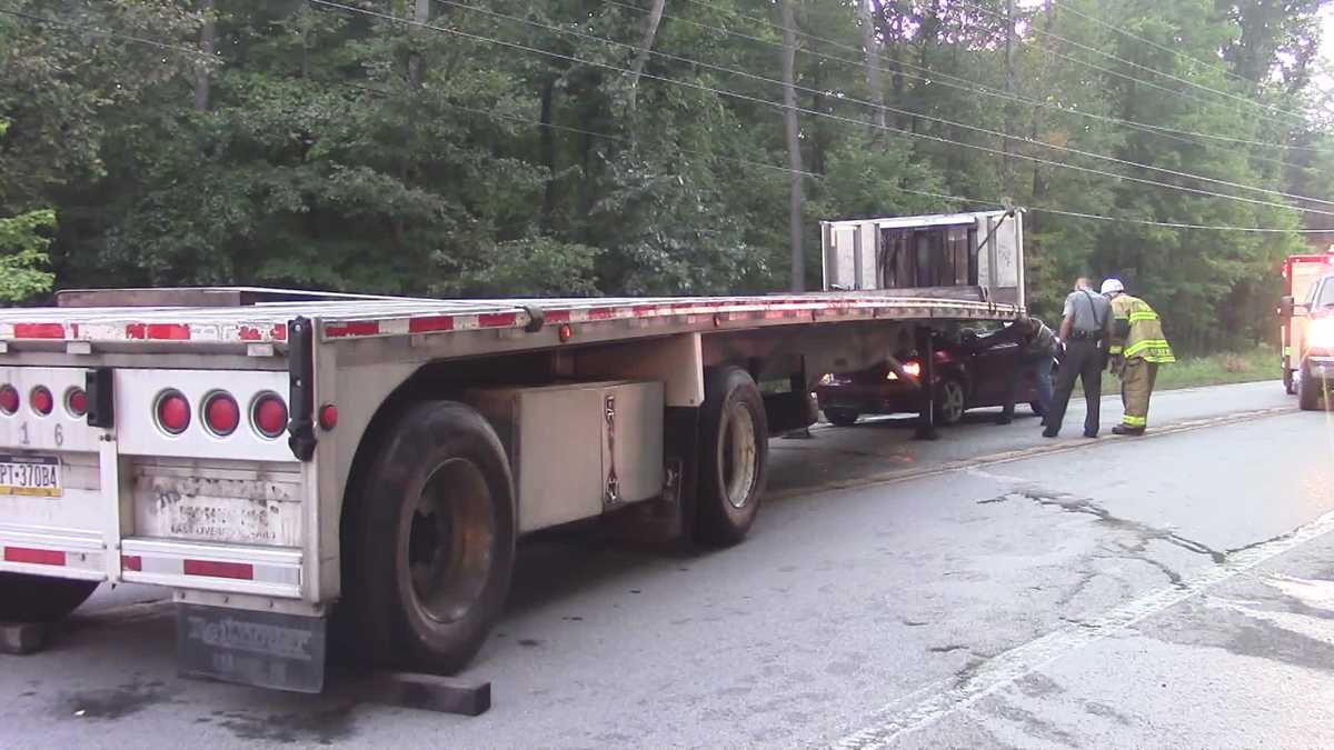 Photos: Car goes under truck's disengaged trailer