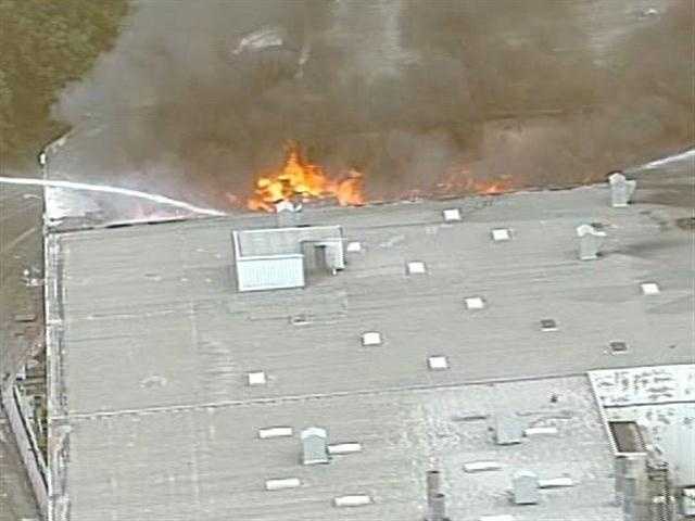 Dozens of firefighters battle flames at textile warehouse
