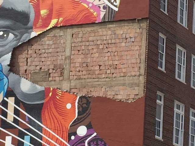 Dozens displaced, 4 injured when brick mural breaks off building