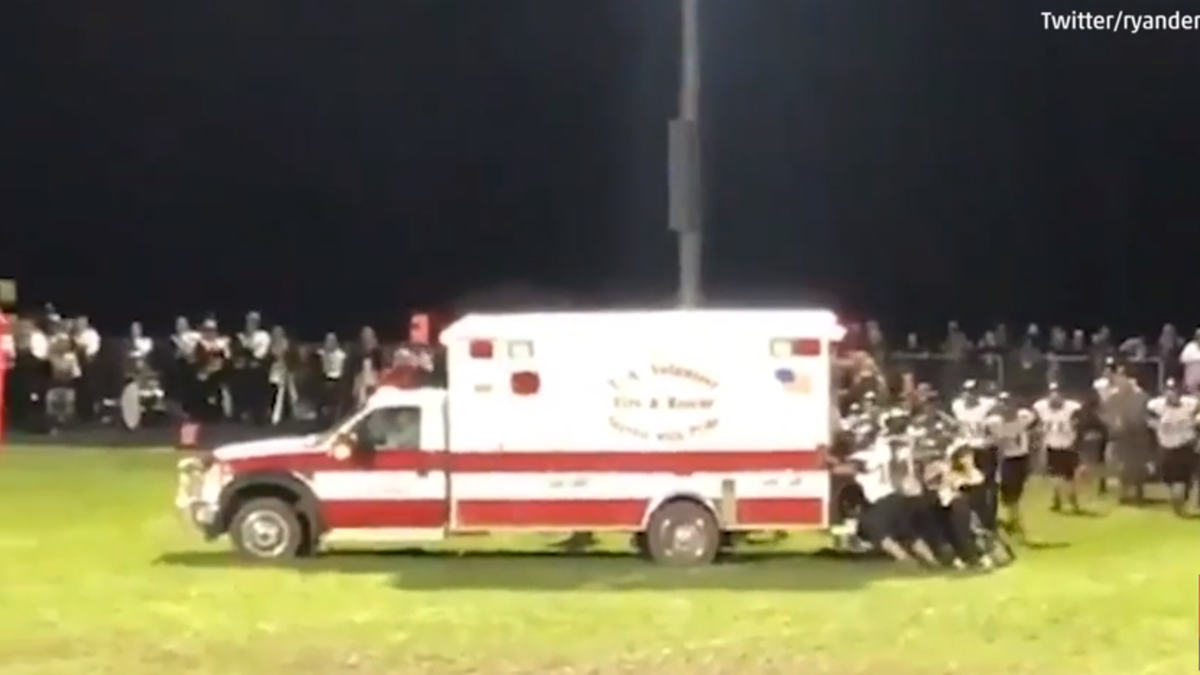 Watch: Football team pushes stuck ambulance off field