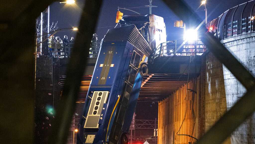 Photos: New York City bus left dangling from overpass after crash