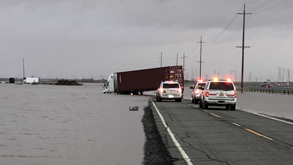 Whoa! Big rig's front end, car swallowed by street flooding