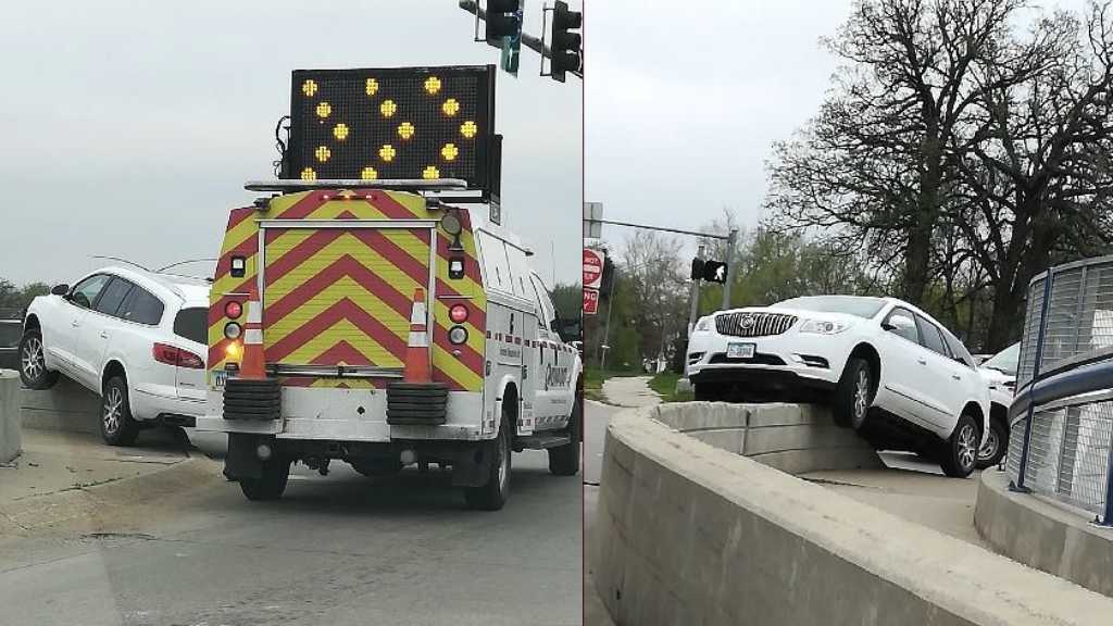 Car left straddling barrier in crash
