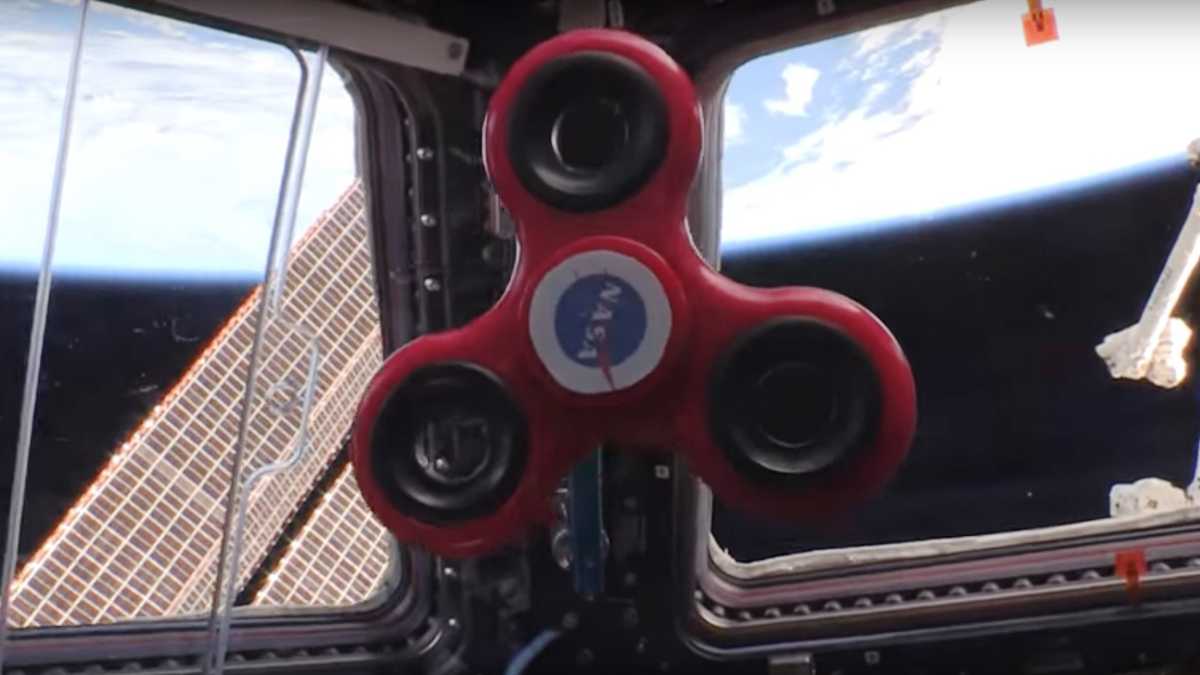 Astronaut playing with fidget spinner in zero gravity is mesmerizing