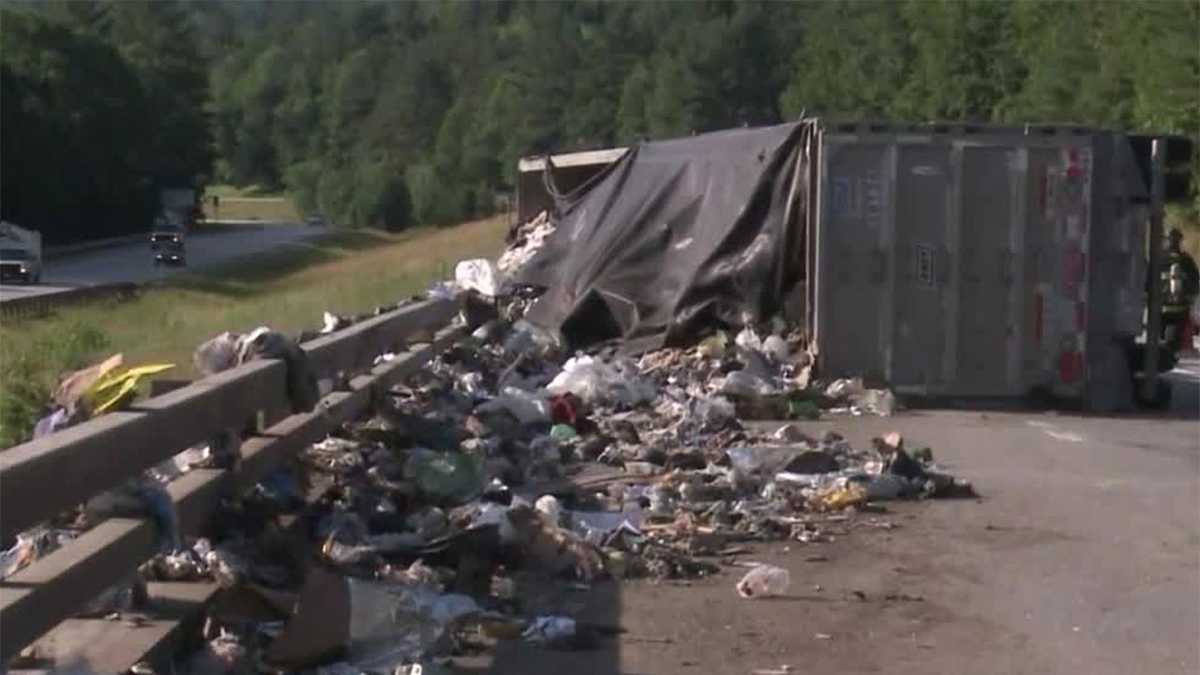 Tractor trailer carrying 60,000 lbs of garbage rolls over blocking ...