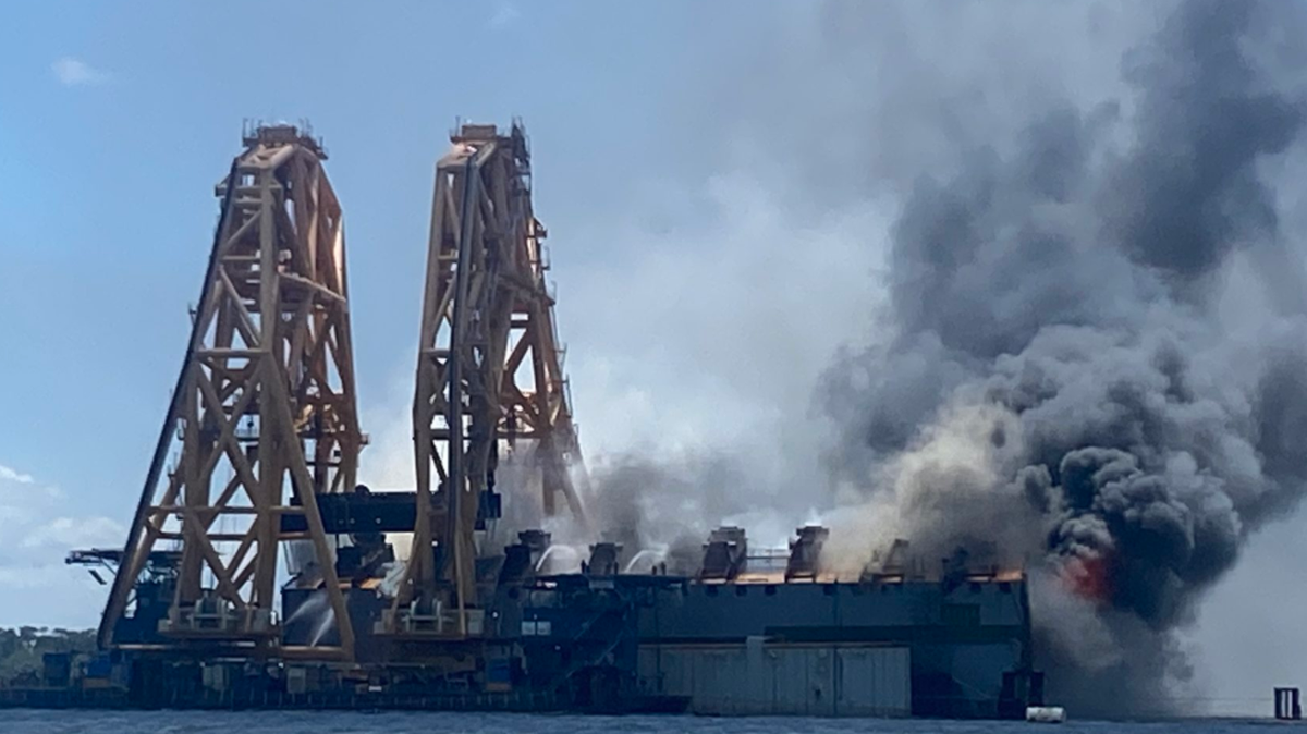 Damage assessment begins on overturned cargo ship after fire