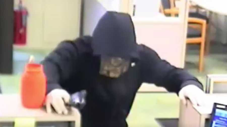 Newly released video shows armed bank robber jumping counter