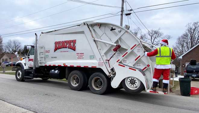 Santa Claus hitches ride on garbage truck, spreads holiday cheer ...