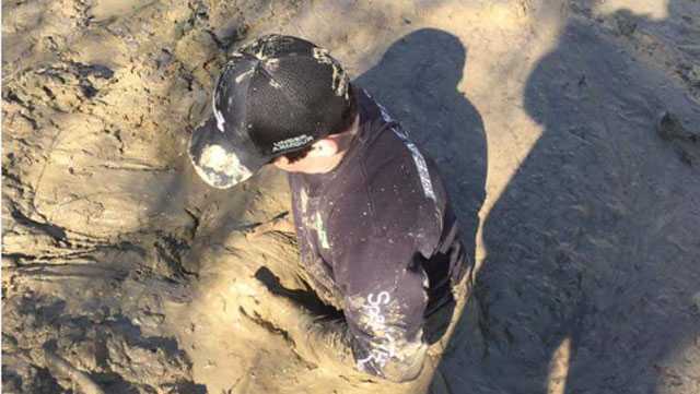 Teen saved from waist-deep mud