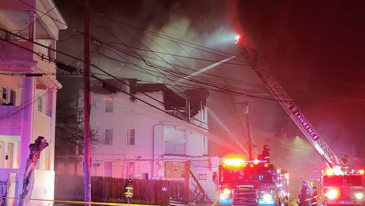 Flames shoot out of roof of Lawrence triple-decker as crews battle fire