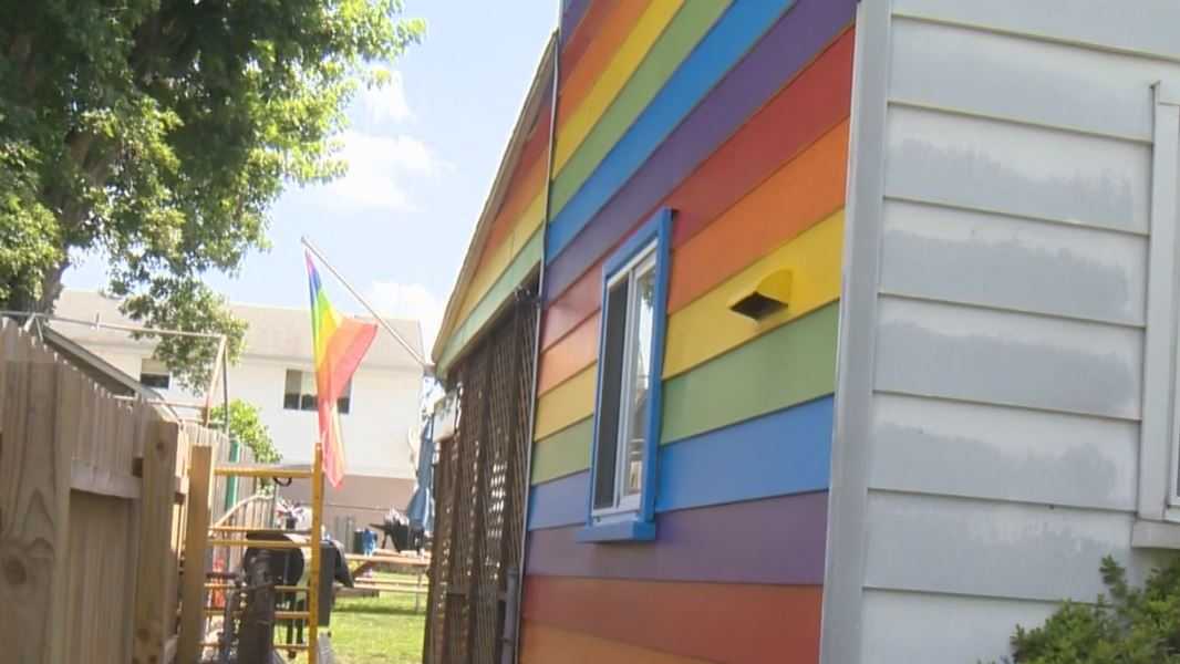 Couple paints LGBT flag on the side of house after neighbors harass them