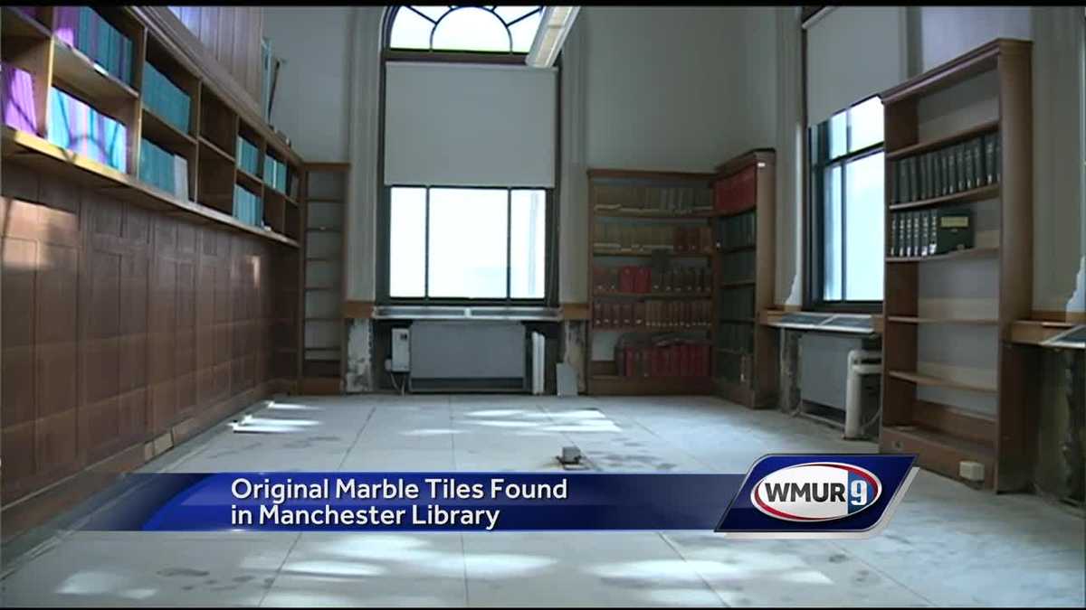 Workers uncover marble floor tiles at Manchester City Library