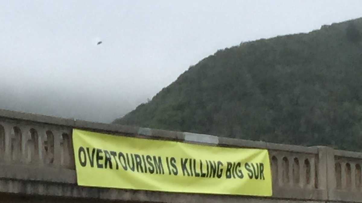 'Overtourism is killing Big Sur' sign draped over Bixby Bridge