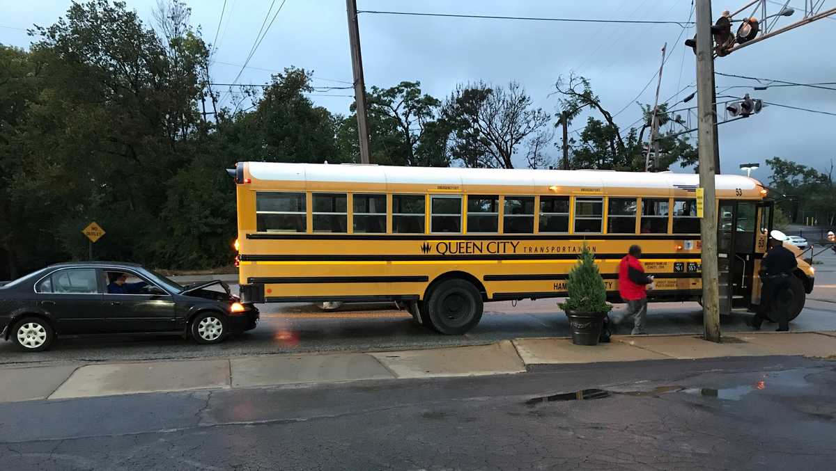 Car strikes, gets wedged under school bus