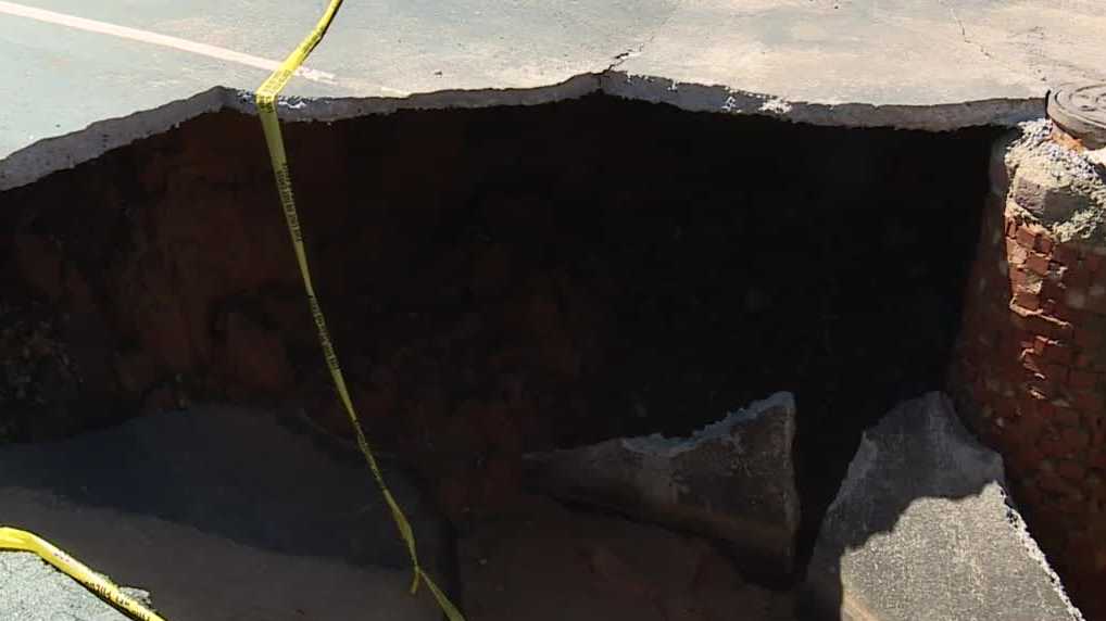 Woman falls in sinkhole after ground collapses at car dealership