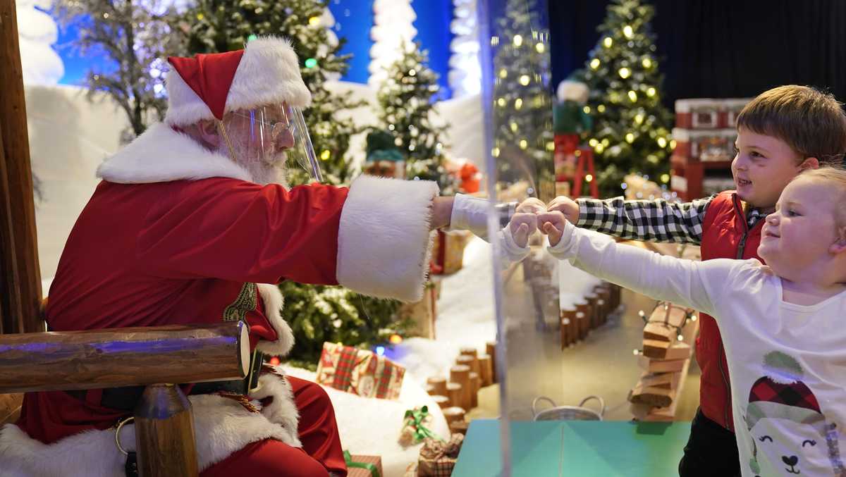 Here comes Santa Claus — with face masks and plexiglass