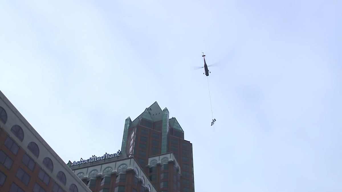 Helicopter hoists lights atop Associated Bank River Center downtown