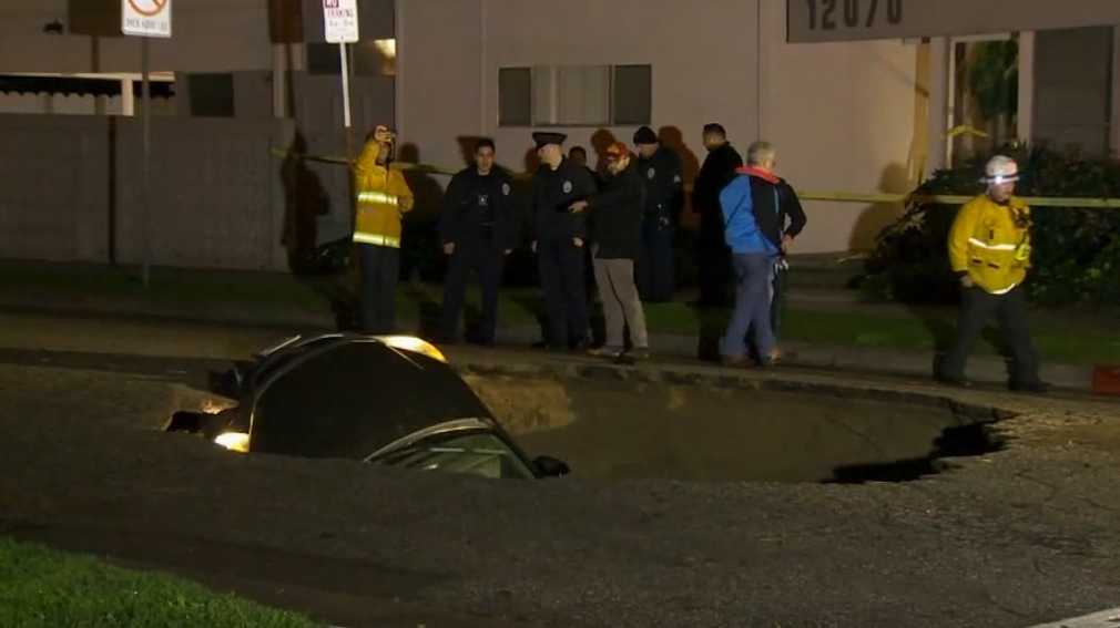 WATCH: Woman rescued after car falls into 20-foot sinkhole