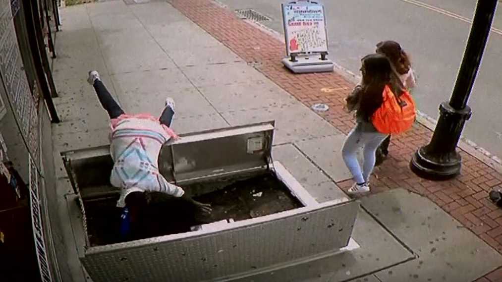 Caught on camera: Woman distracted by cellphone falls down cellar door