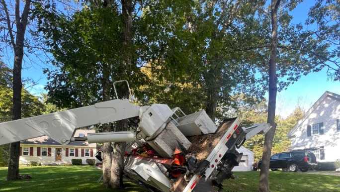 Worker freed after bucket truck tips in front of Maine home