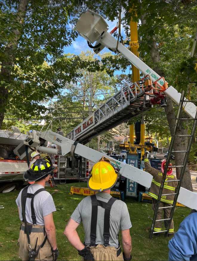 Worker freed after bucket truck tips in front of Maine home