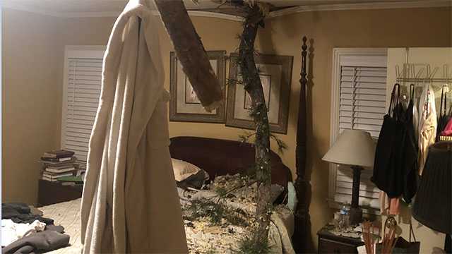 Family working to repair roof after a tree fell on their house