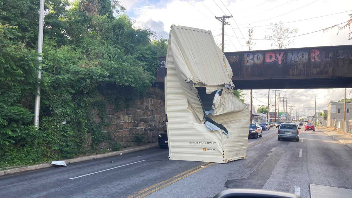 Truck carrying container crashes into railroad bridge